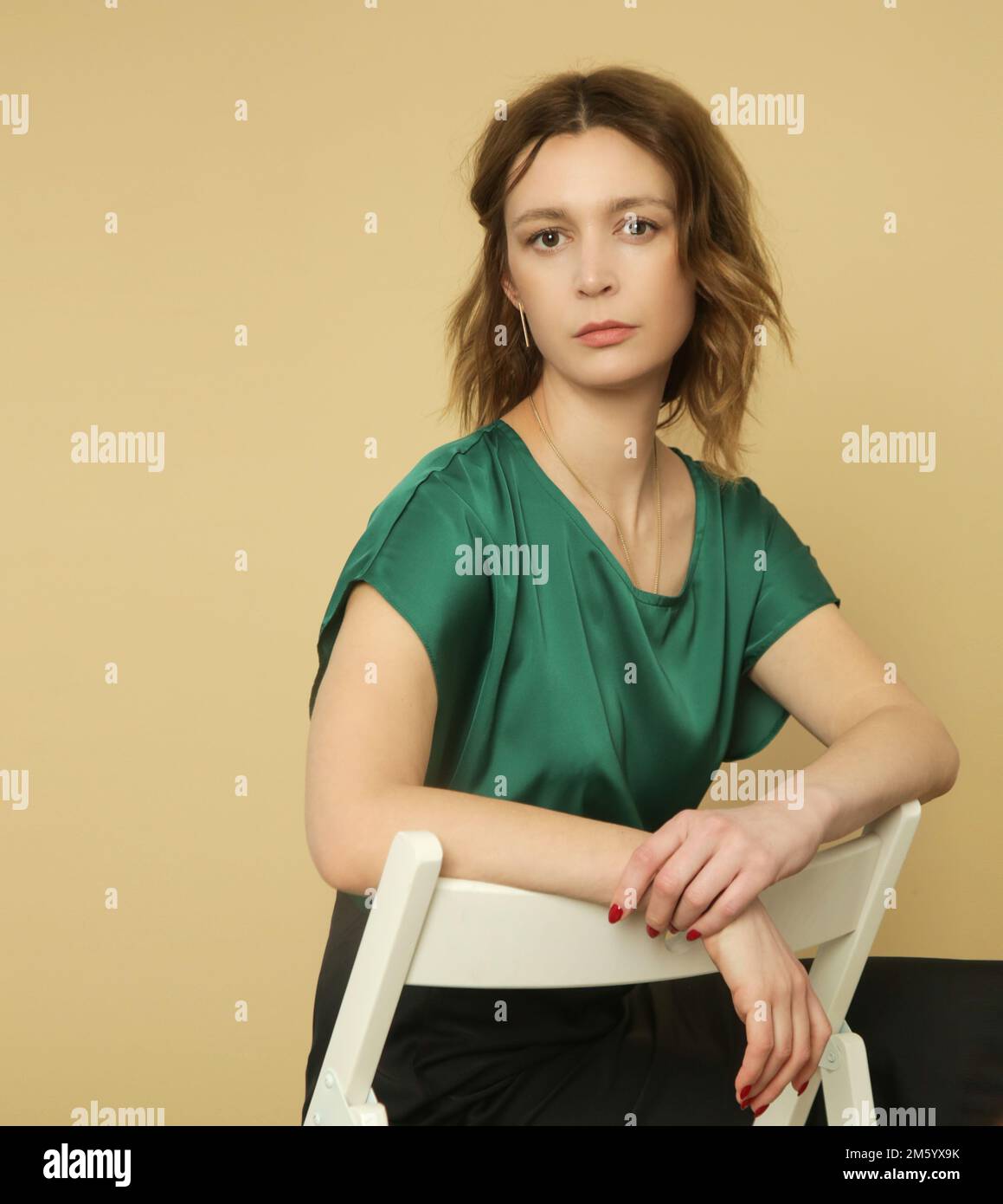 Serie of studio photos of young female model wearing green blouse and ...