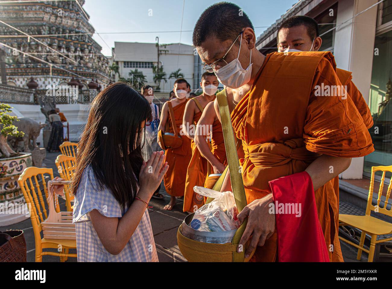 Buddhist monk receives alms from a girl during the morning alms giving ...