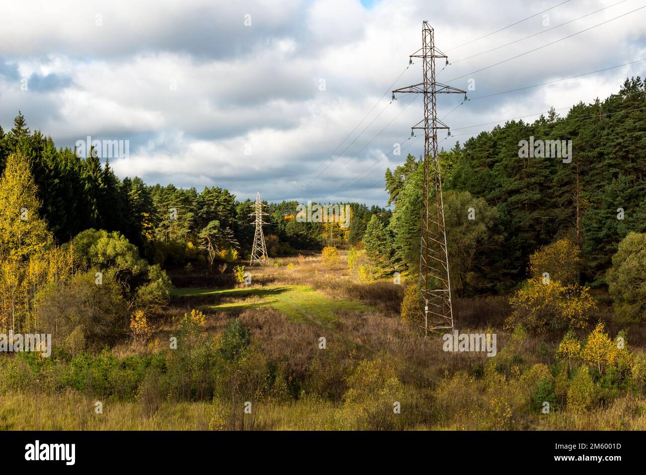 High-voltage power line passing through a picturesque valley surrounded ...