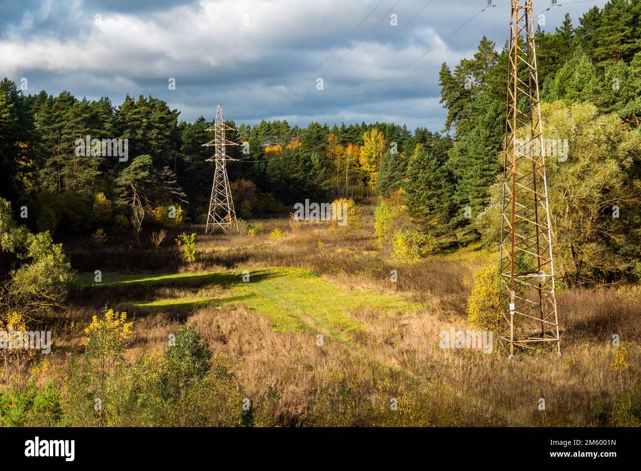High-voltage power line passing through a picturesque valley surrounded ...