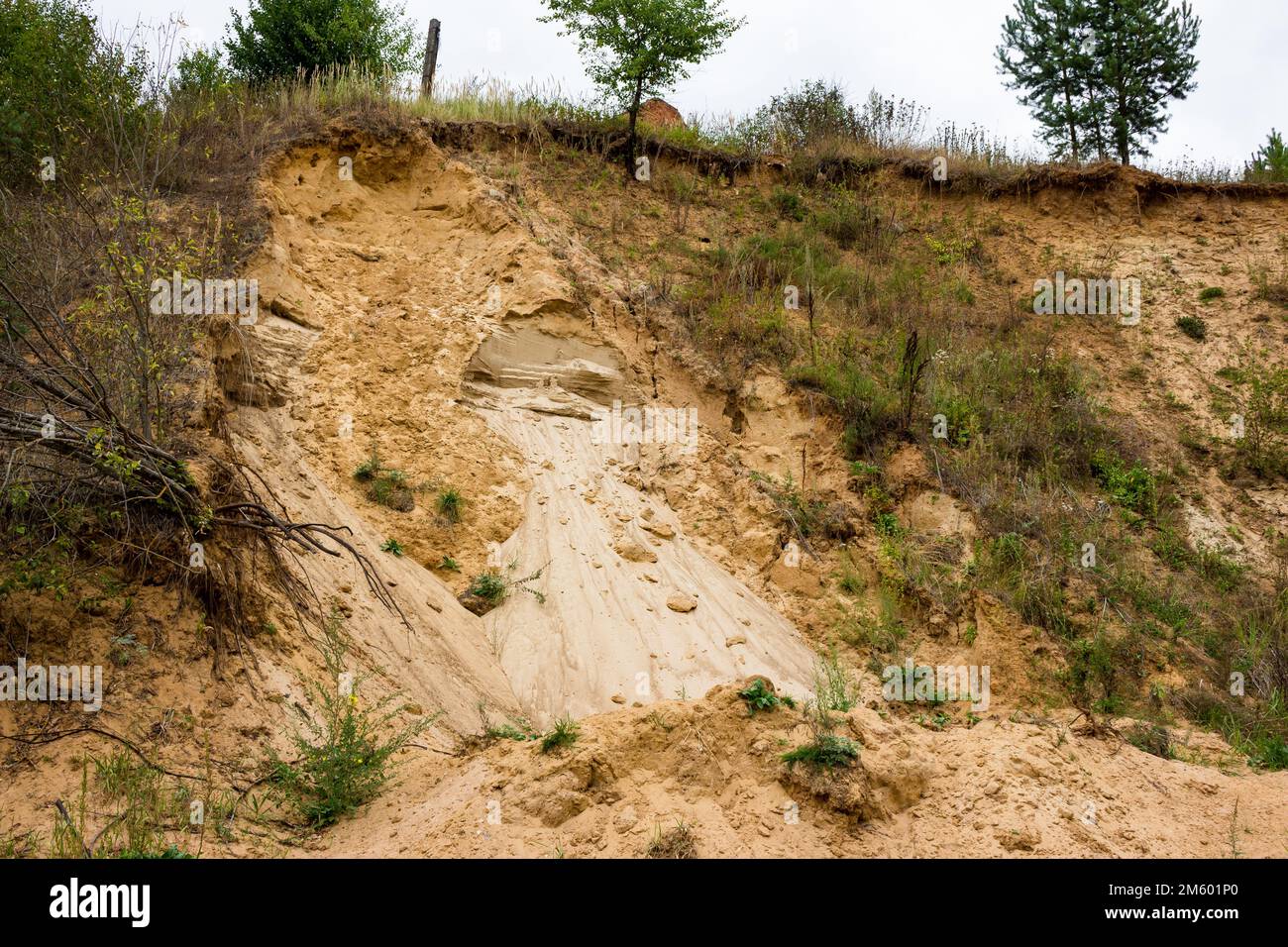 Creeping fine-grained sand on the slope of a sand pit, artisanal mining ...