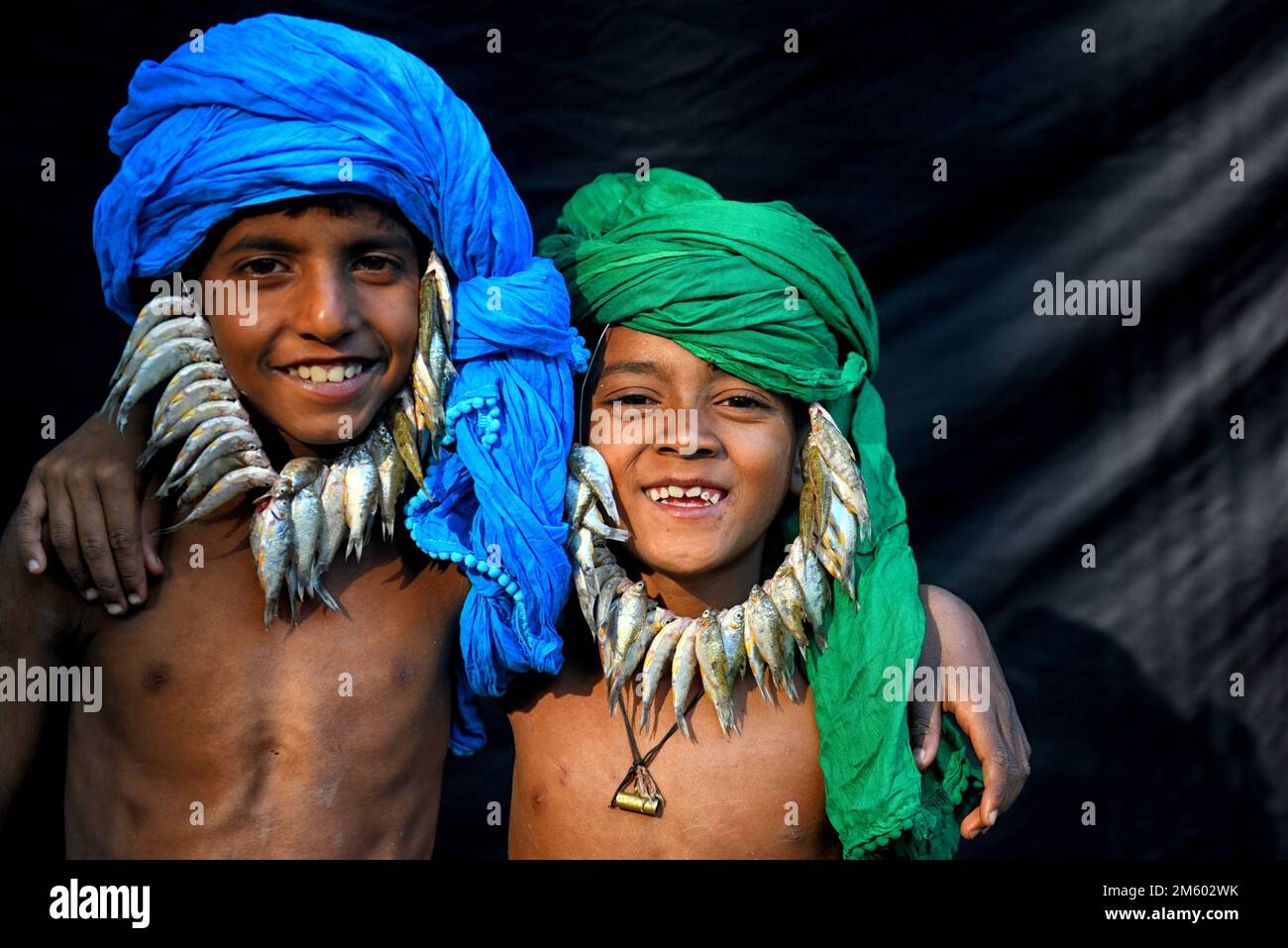 Young kids pose for photos with fish rings around their necks on the ...