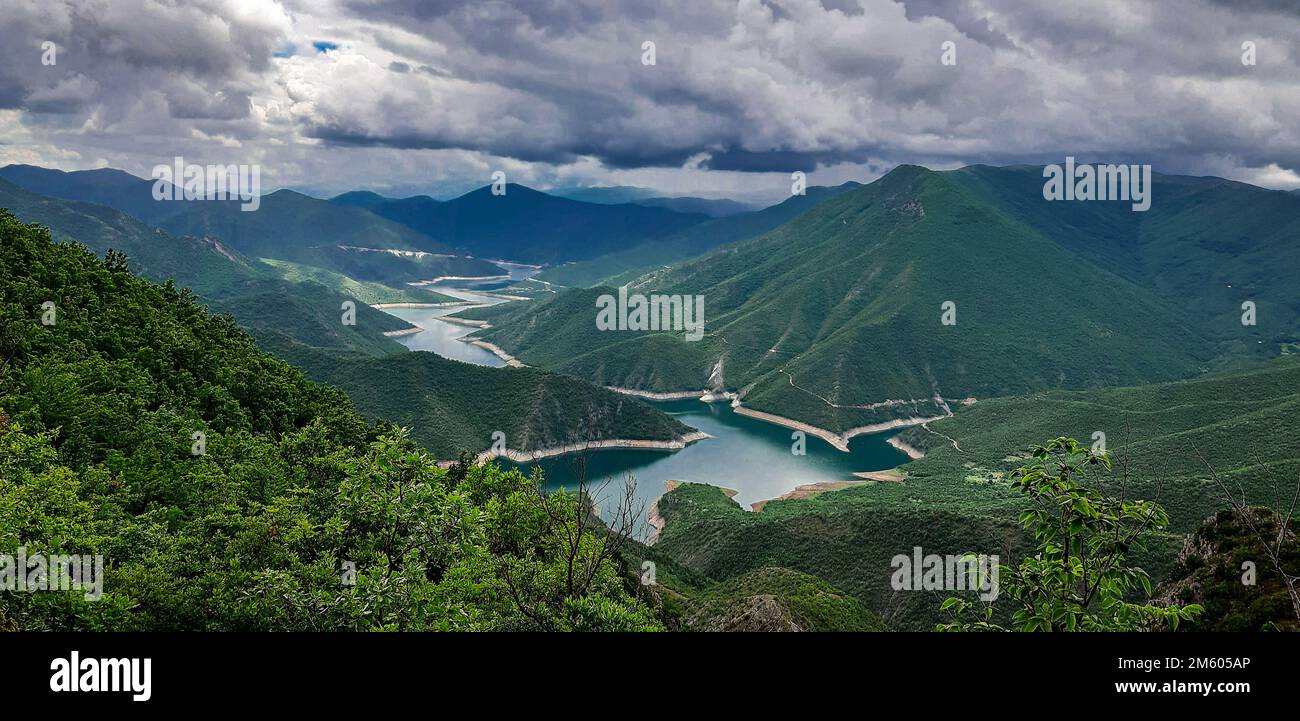 A panoramic view of a river surrounded by scenic mountains Stock Photo ...
