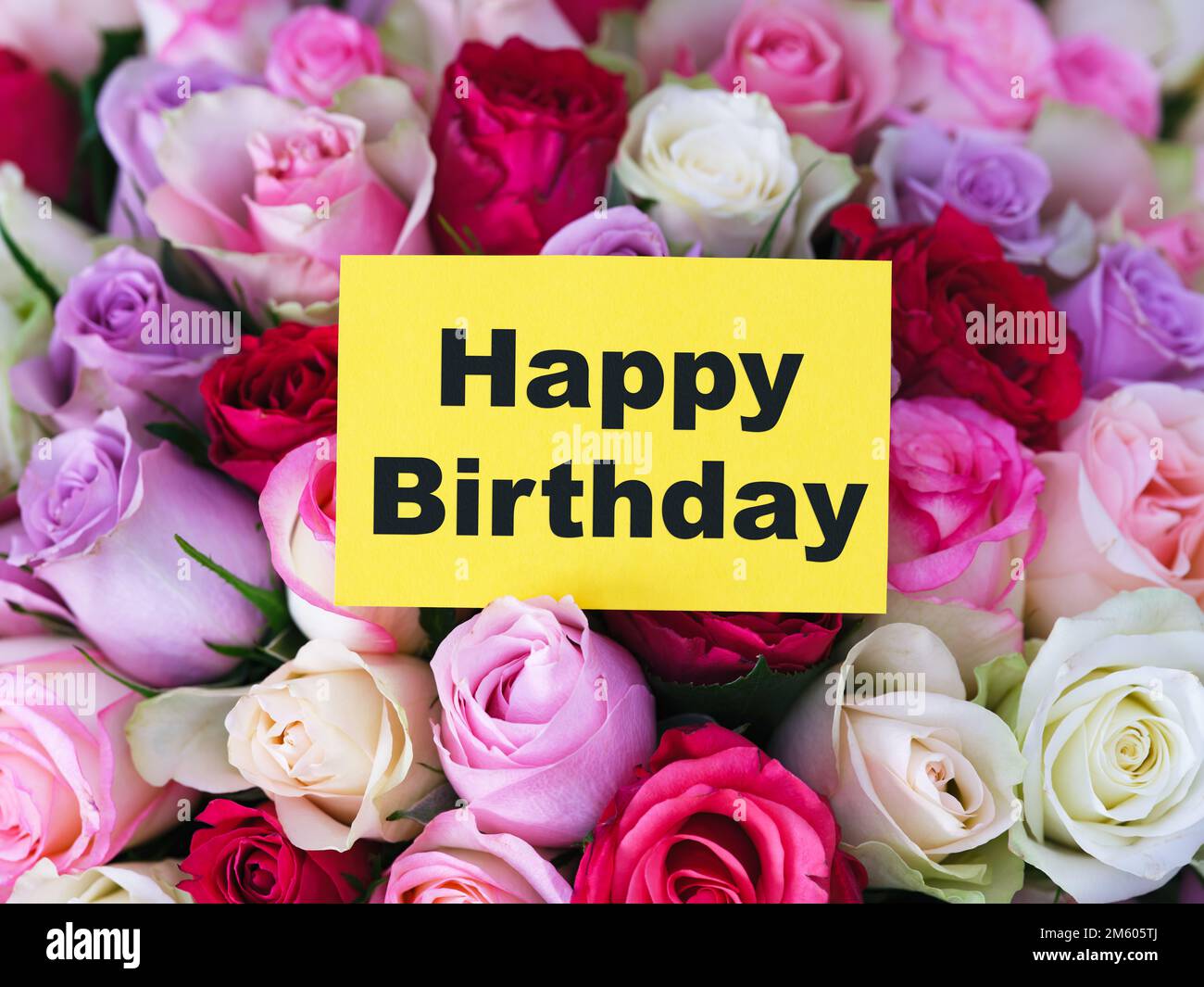 A yellow greeting card with words Happy Birthday laying on a big ...