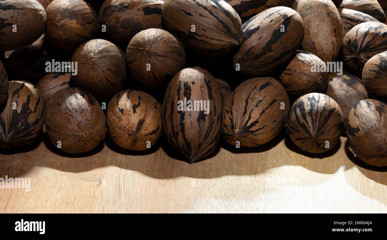 Pile of pecans ready to be shelled on a wood table Stock Photo - Alamy