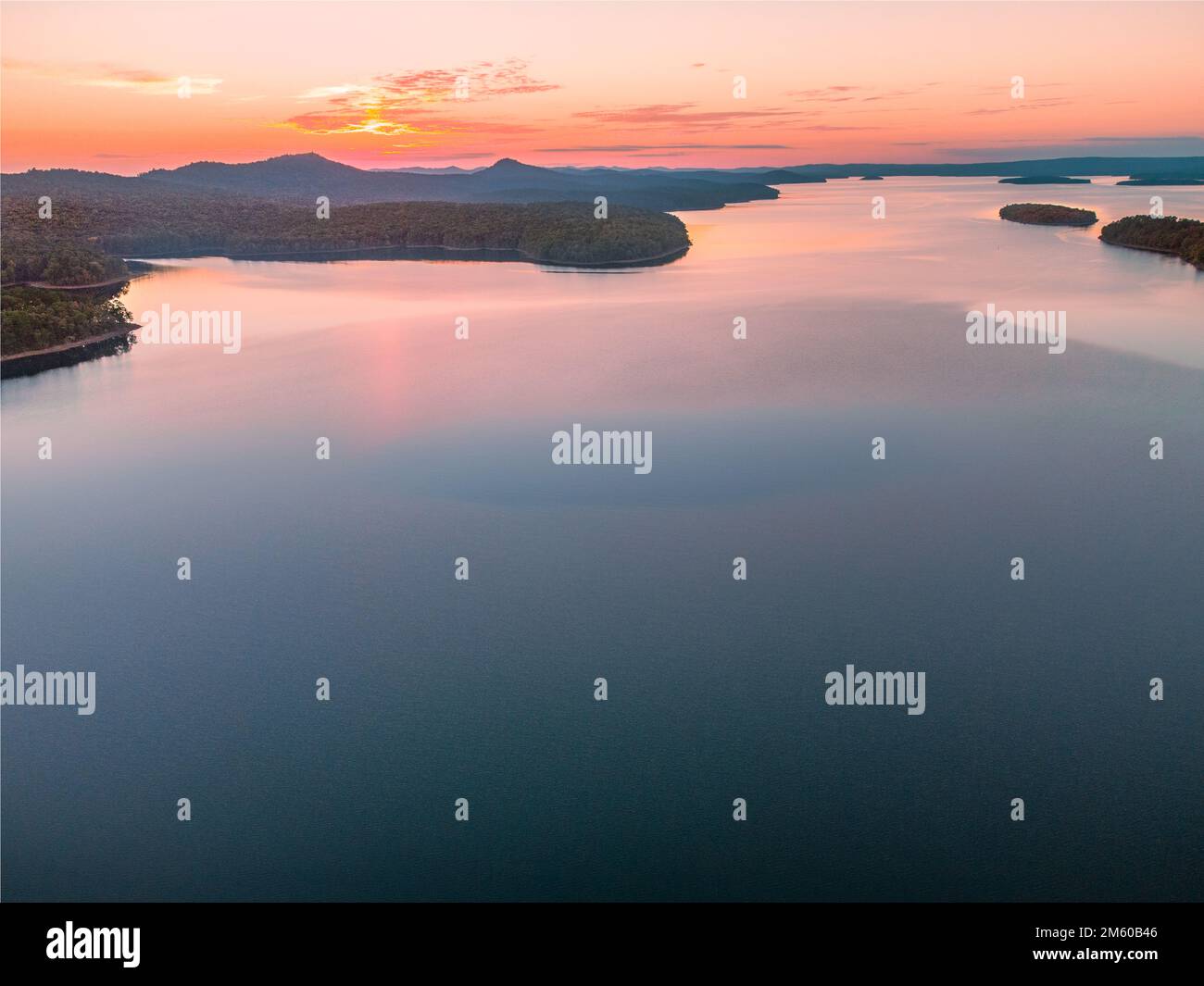 A bird's eye view of a lake surrounded by trees at sunset Stock Photo ...