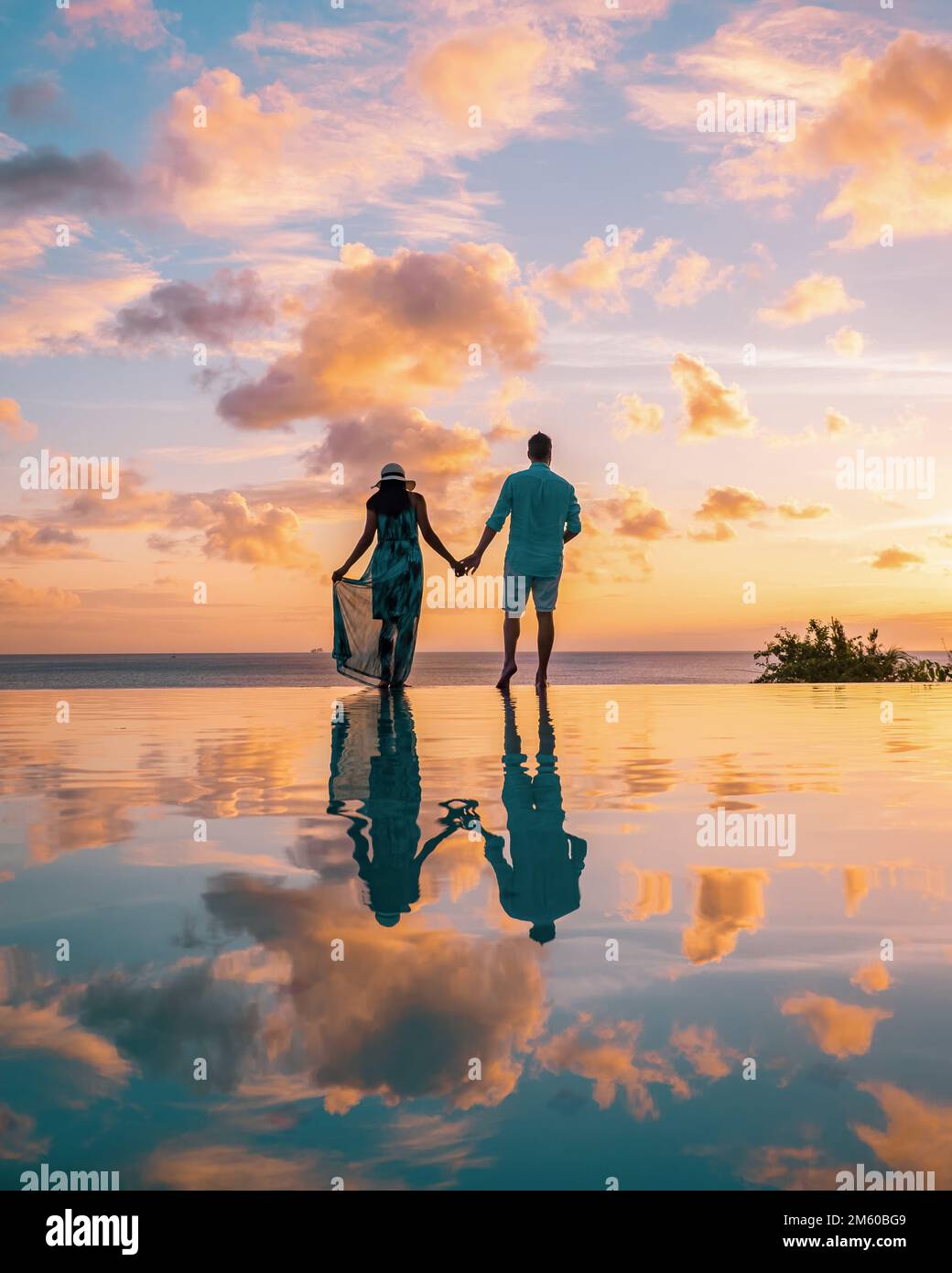 couple watching sunset at infinity pool Saint Lucia, couple on vacation ...