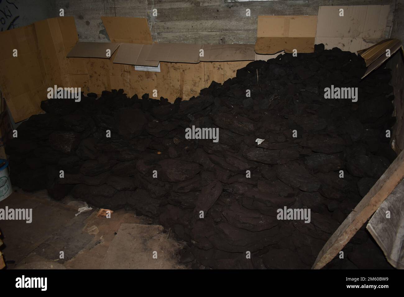 Stack of coal for heating in the basement Stock Photo - Alamy