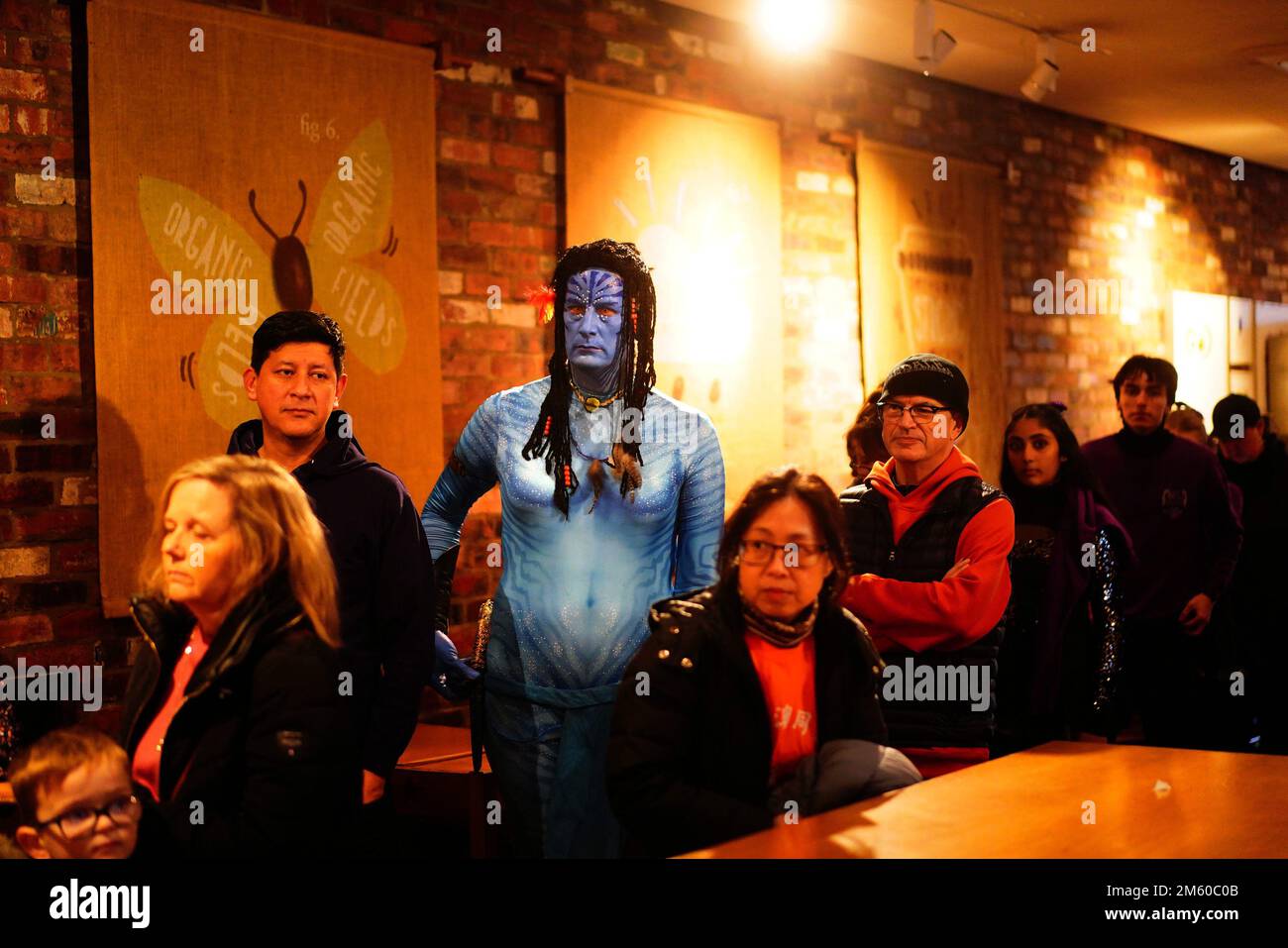 A performer in an Avatar costume in a queue for the toilets in a cafe ...