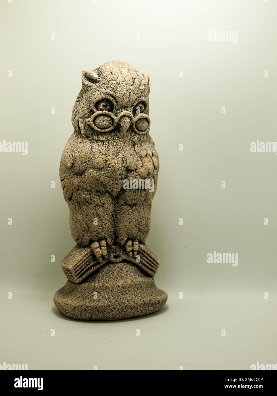 A vertical shot of an owl stone statue on a white background Stock ...