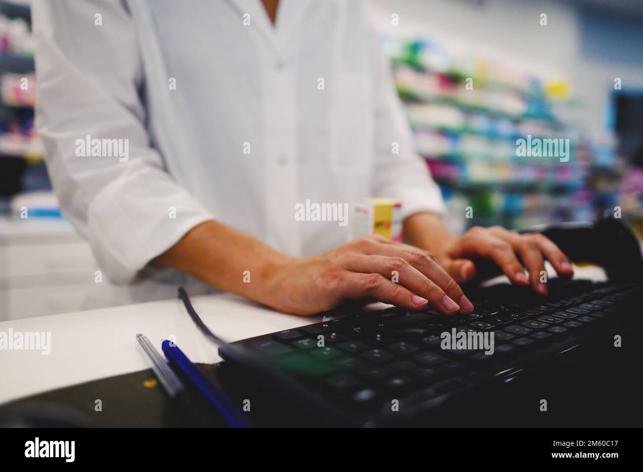Pharmacist woman works at computer at the pharmacy counter Stock Photo ...
