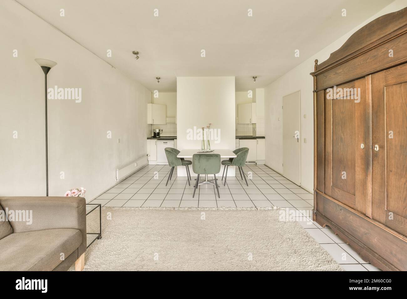 a living room with a couch, chair and dining area in the back wall is ...