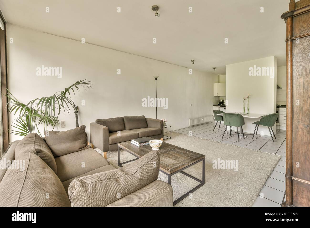 a living room with couches, chairs and a coffee table in front of a ...