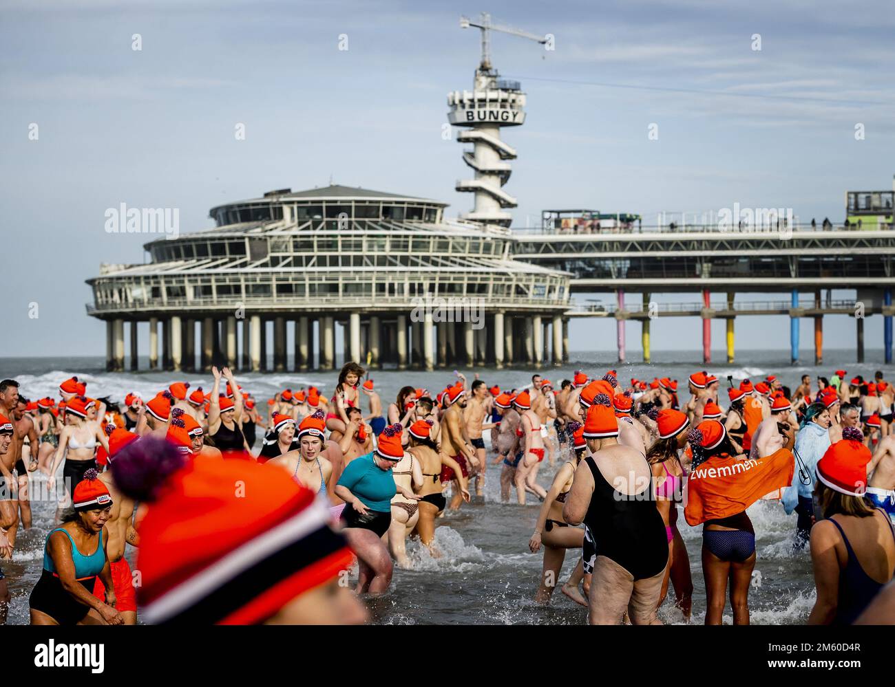 SCHEVENINGEN - People run into the sea at the beach of Scheveningen on ...