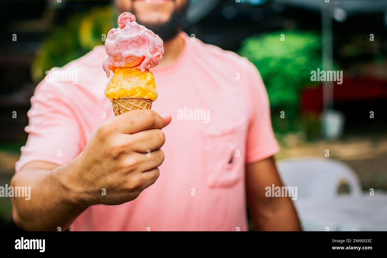Front view of person hands holding an ice cream cone. Unrecognizable ...