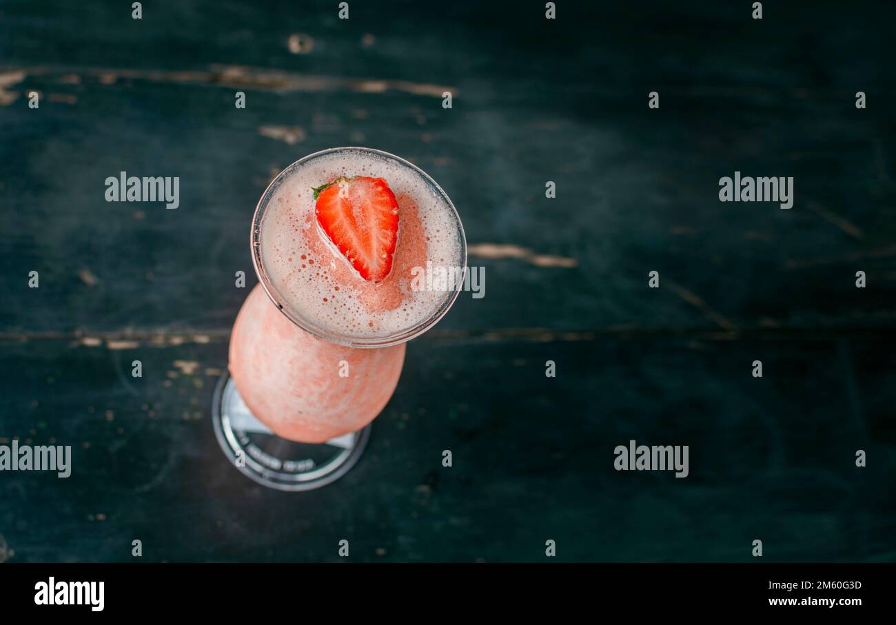 View of strawberry milkshake on dark wood. View from above of delicious ...