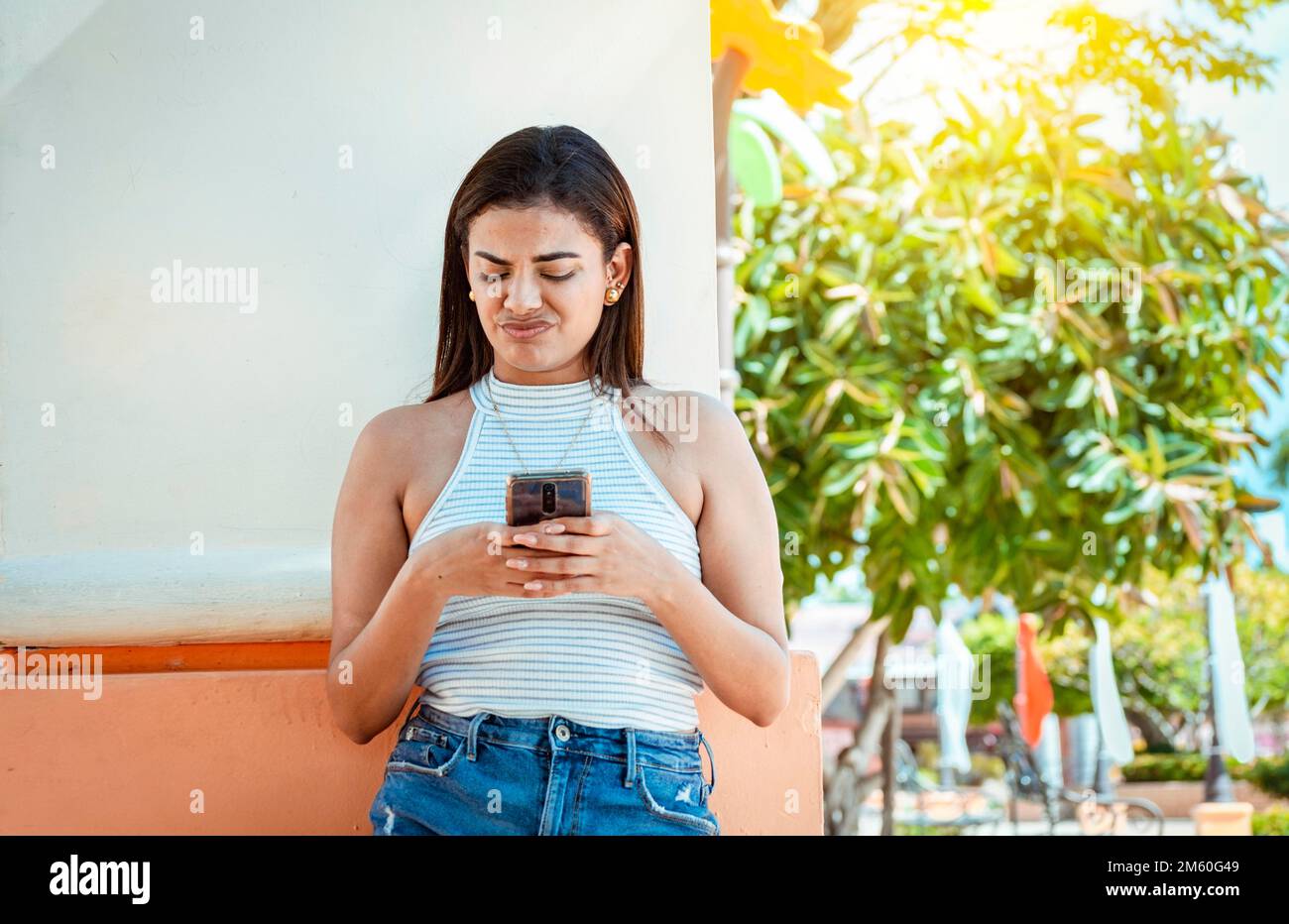 Girl with the cell phone receiving an unpleasant message. Young woman ...