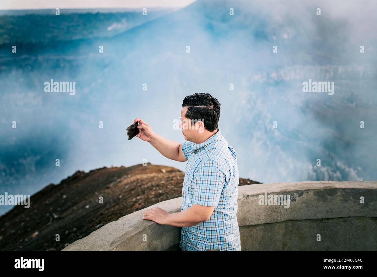 Tourist man taking photos at a viewpoint. Young tourist man taking ...