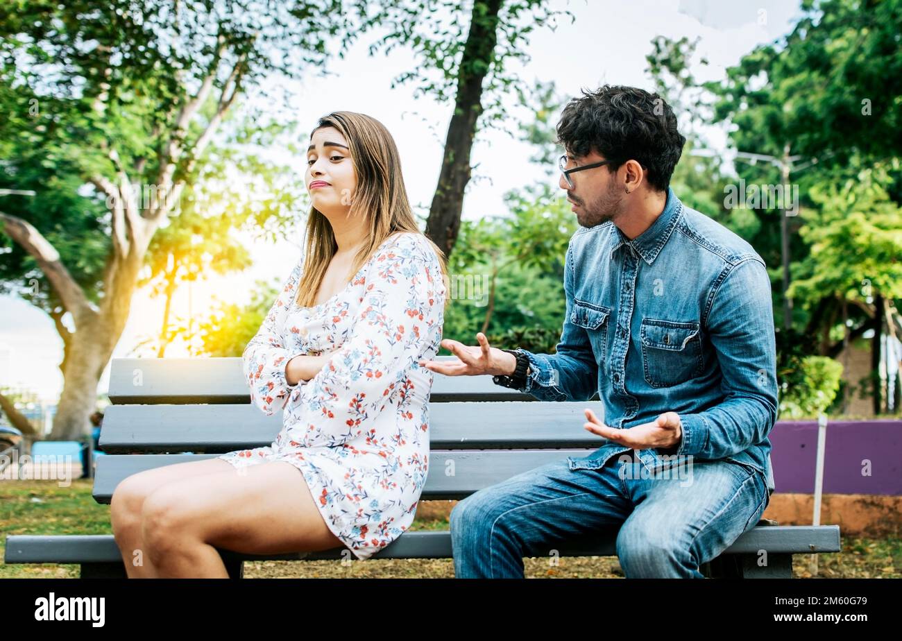 Man arguing with his girlfriend sitting in a park. Upset couple arguing ...