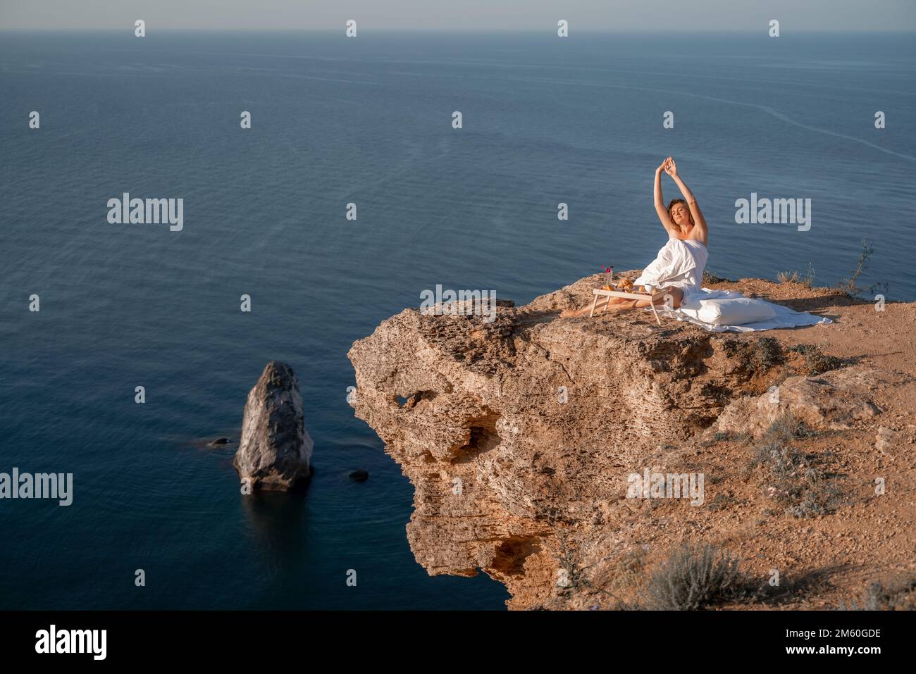 Woman wake up in bed wuth duvet and pillow over nature sea background ...