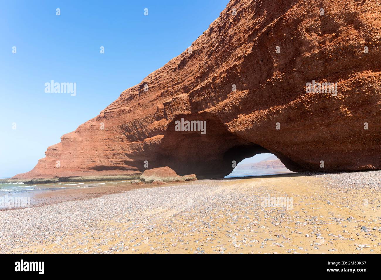 Natural rock coastal arch erosional landform on beach, Legzira ...