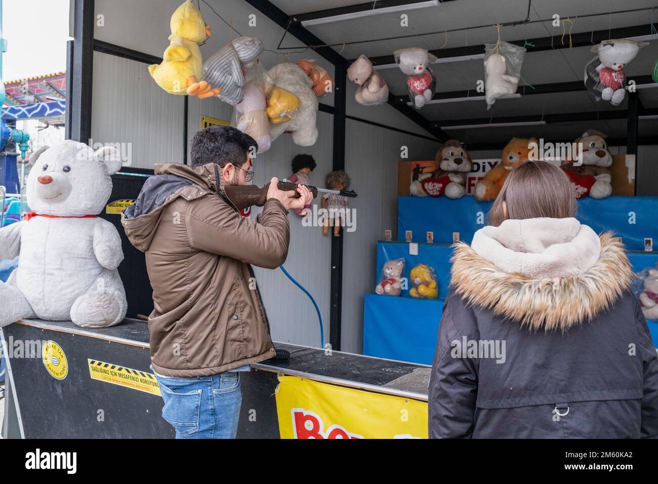A teenager is seen playing the target game with a rifle in her hand ...