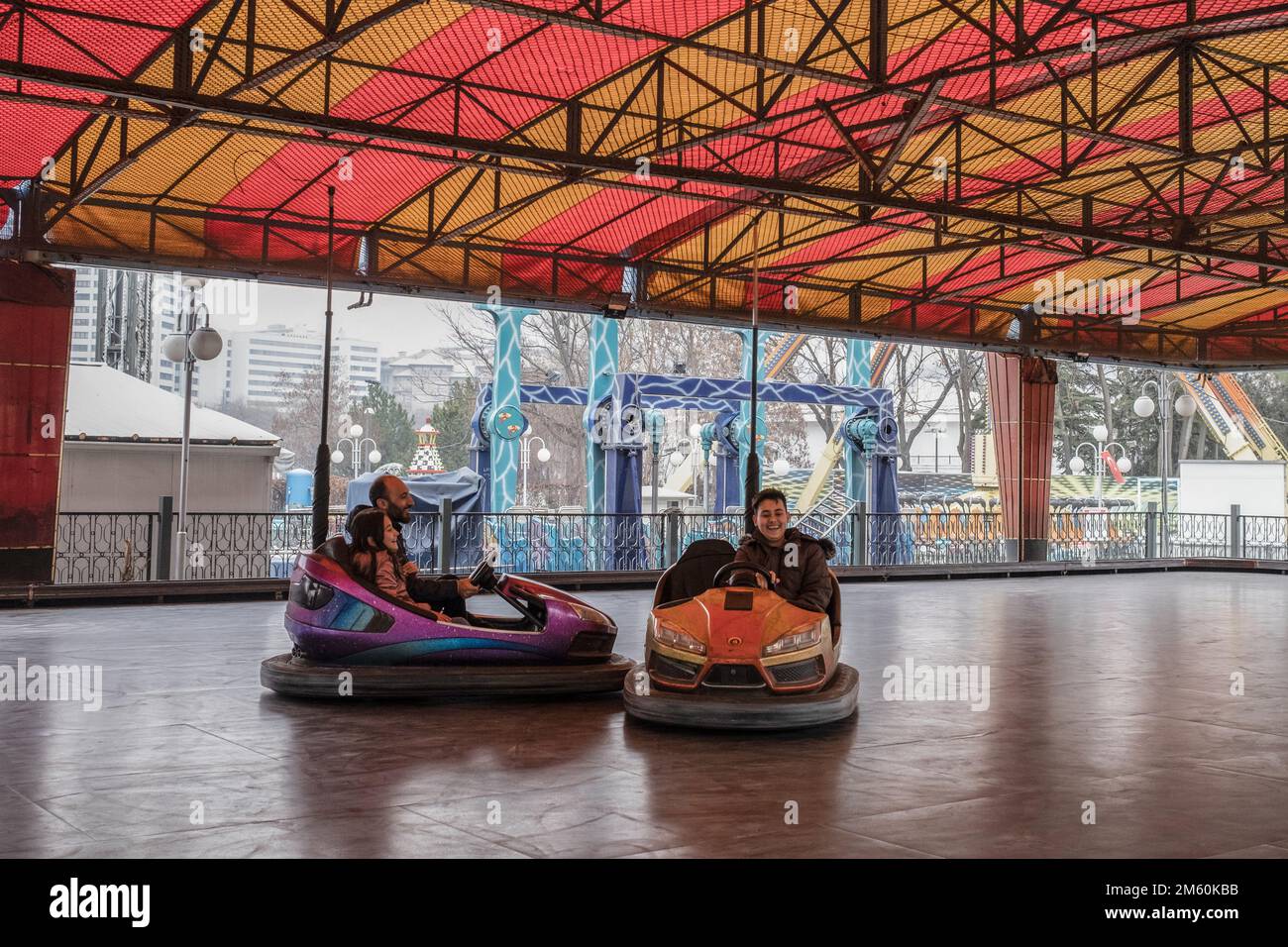 Children have a good time driving bumper cars with their parents at the ...