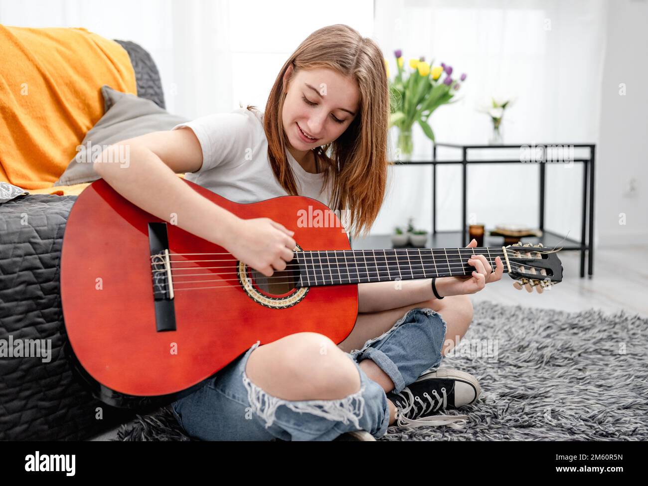 Girl teenager practicing guitar playing Stock Photo - Alamy