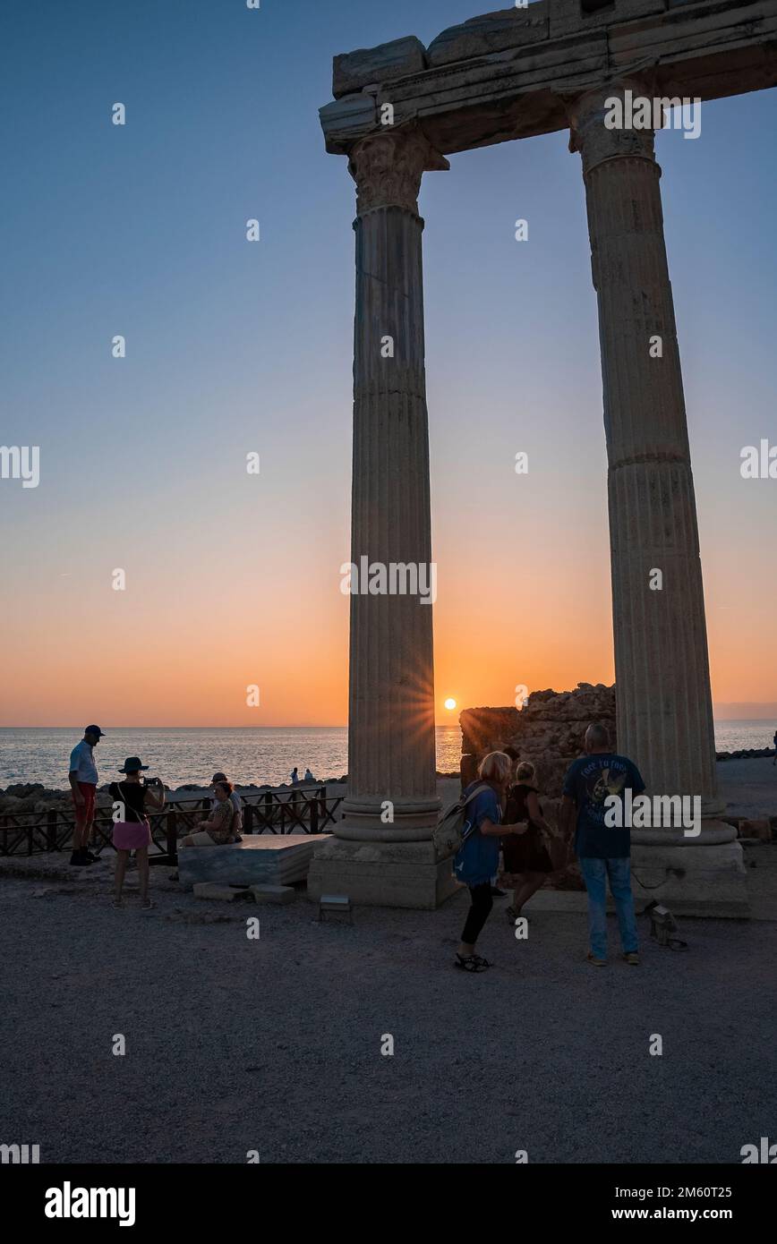 People exploring the Temple of Apollo at beach during sunset Stock ...