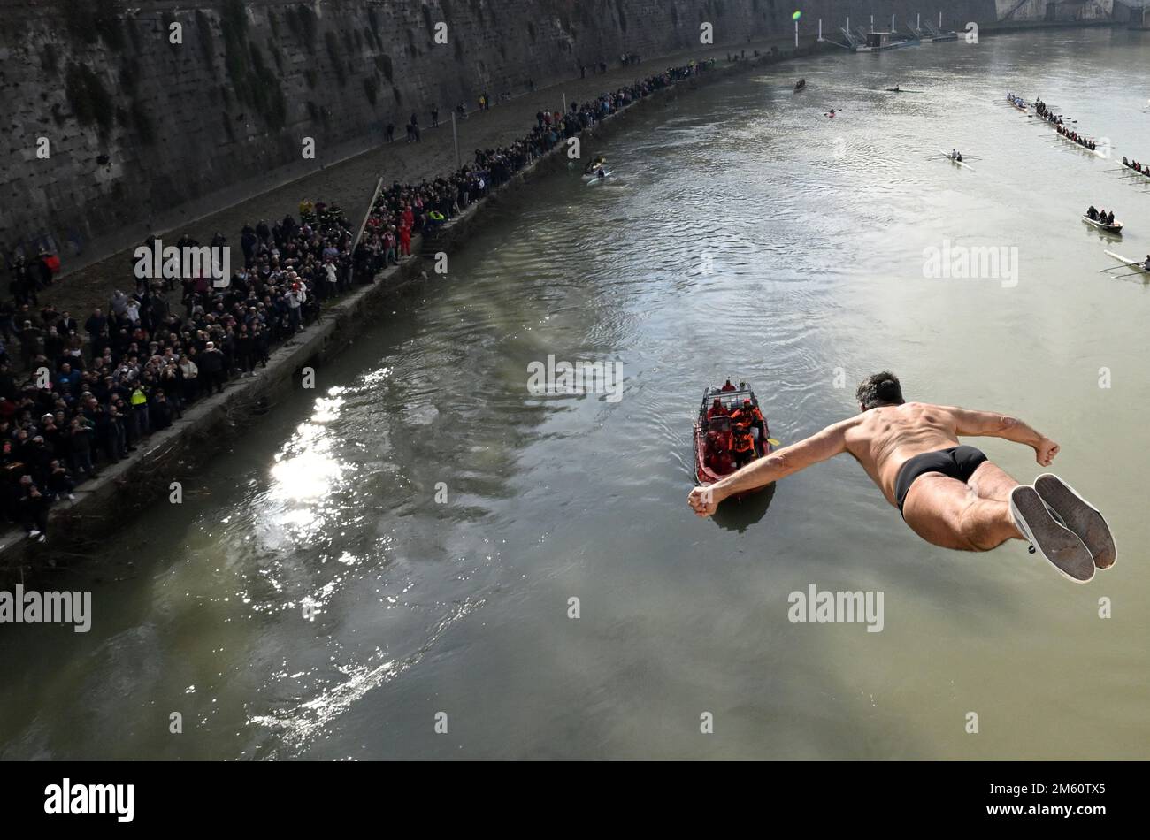 Rome, Italy. 1st Jan, 2023. A man dives into the Tiber River from the ...
