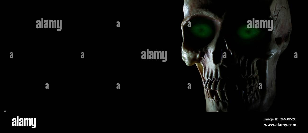 Green eyed human skull with copy space on black Stock Photo - Alamy