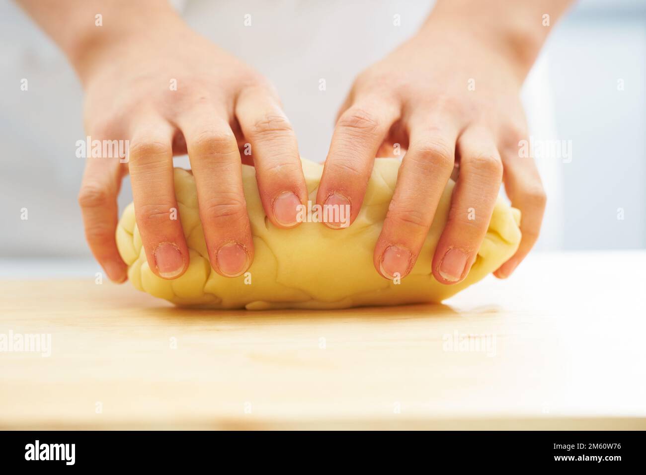 Rolling the dough with a rolling pin, bread making process Stock Photo - Alamy