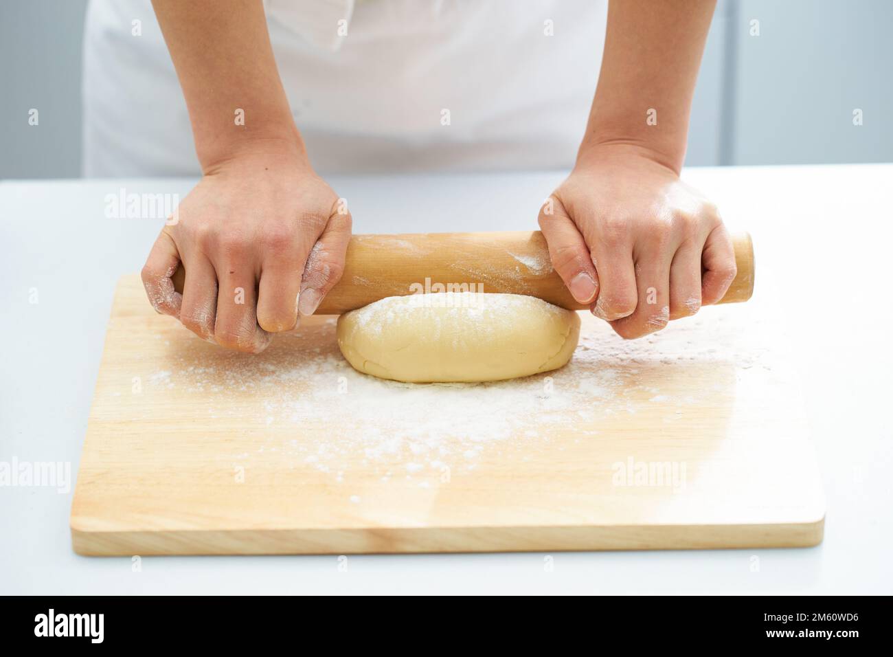 Rolling the dough with a rolling pin, bread making process Stock Photo ...