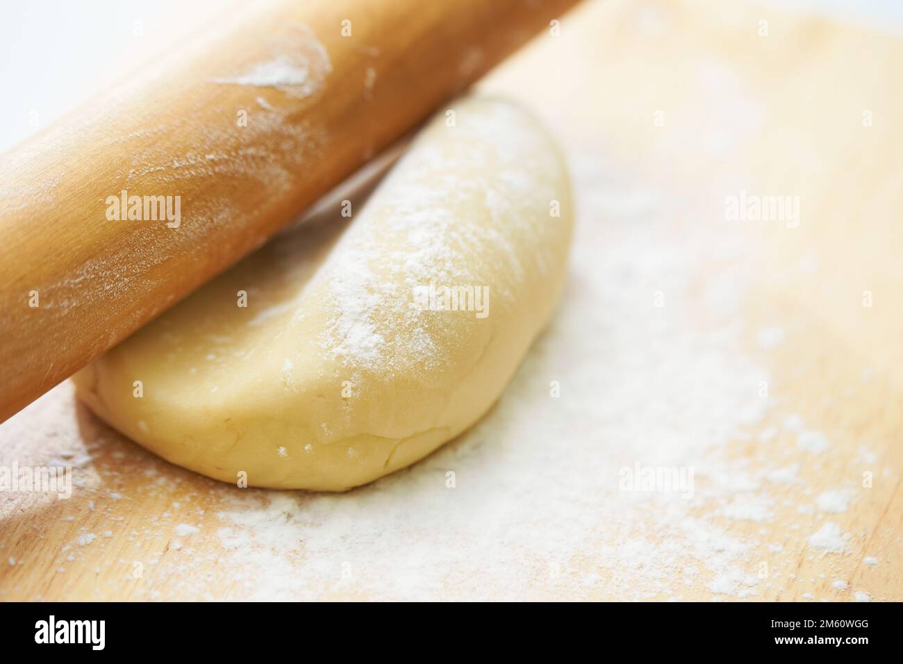 Rolling the dough with a rolling pin, bread making process Stock Photo ...