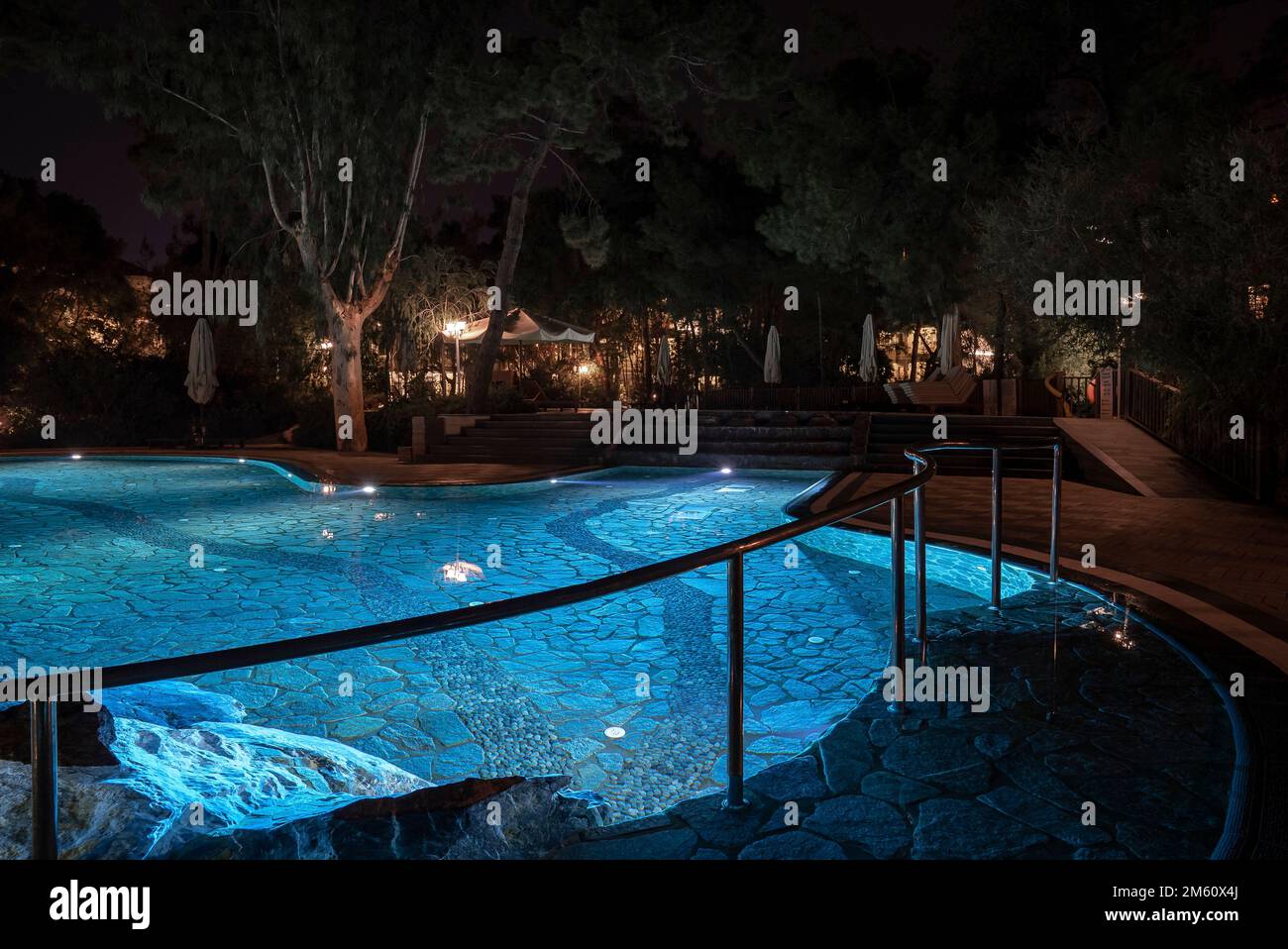 Railing by illuminated swimming pool at night in tourist resort Stock ...