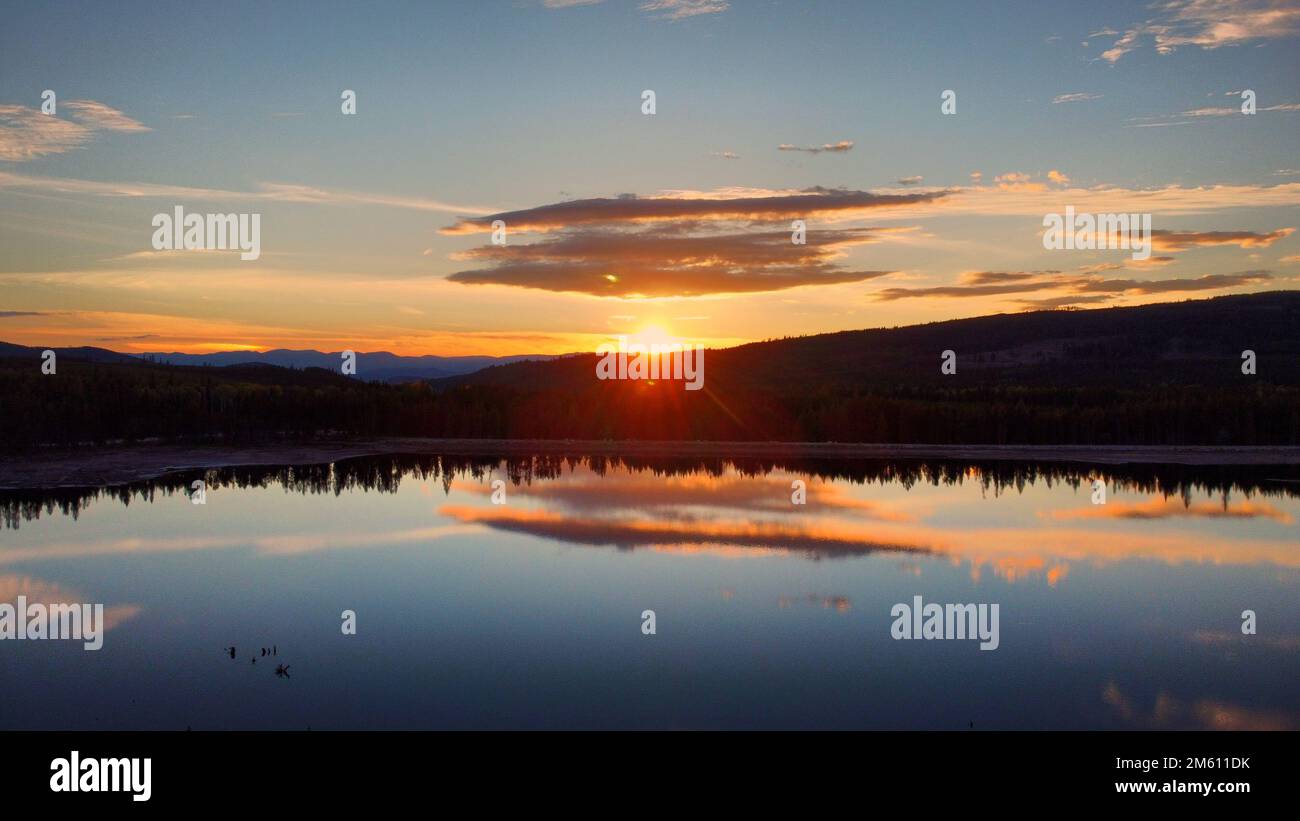A stunning sunrise over a lake with the sky reflection on the surface ...