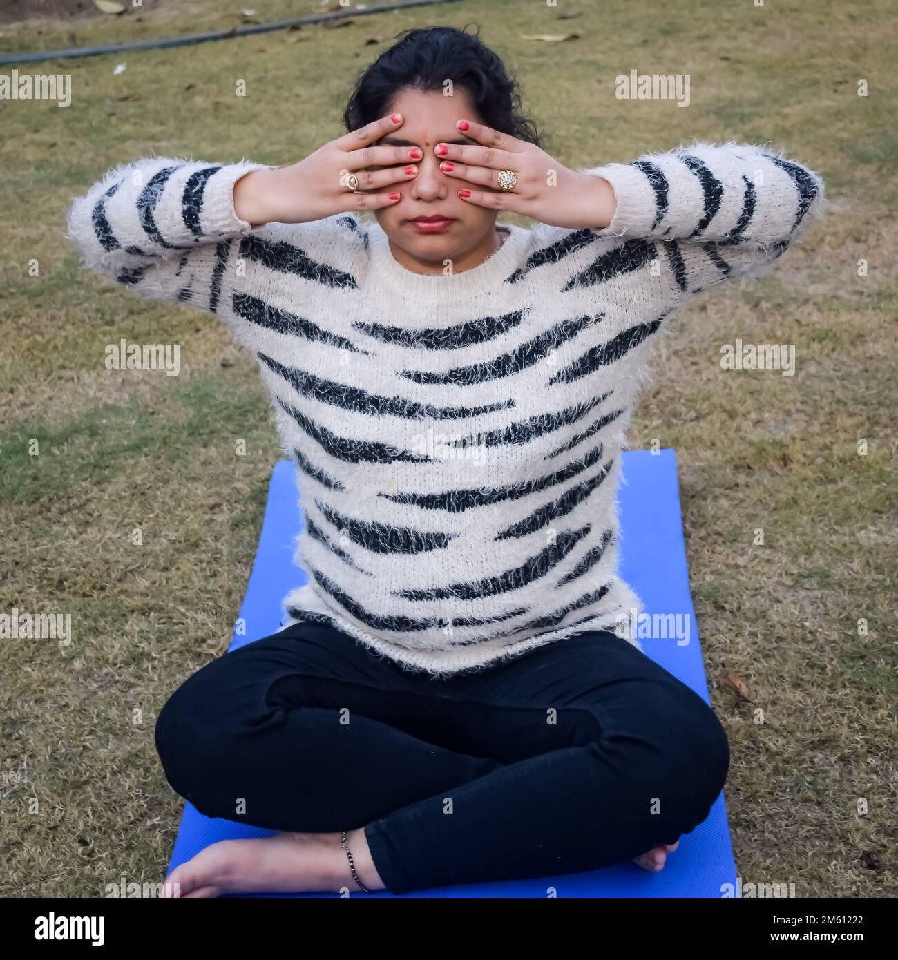 Young Indian woman practicing yoga outdoor in a park. Beautiful girl ...