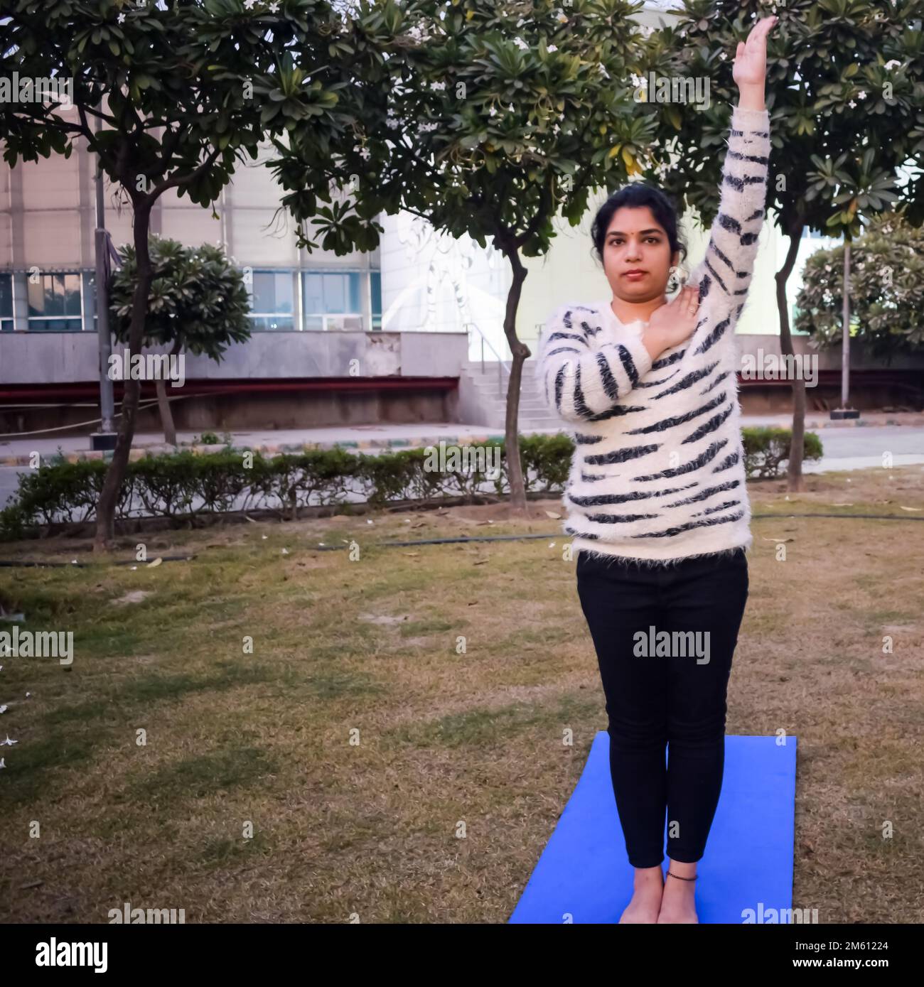 Young Indian woman practicing yoga outdoor in a park. Beautiful girl ...