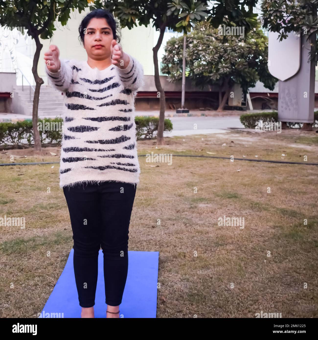 Young Indian woman practicing yoga outdoor in a park. Beautiful girl ...