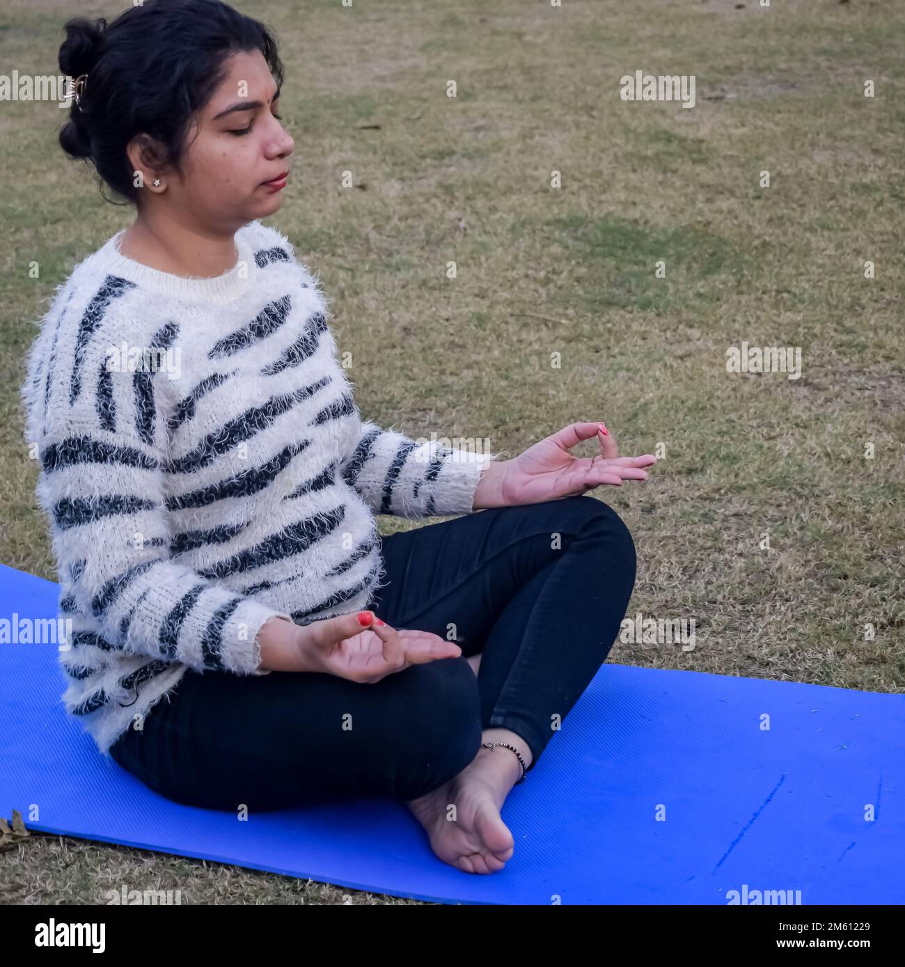 Young Indian woman practicing yoga outdoor in a park. Beautiful girl ...
