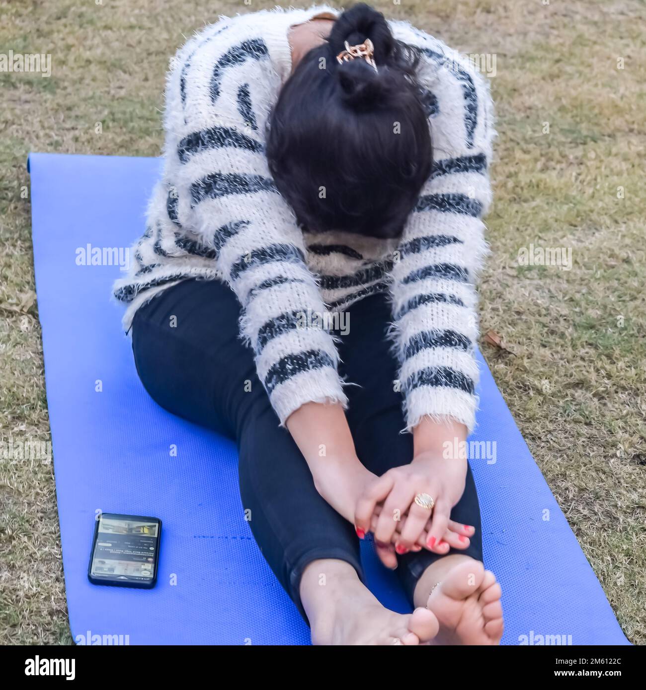 Young Indian woman practicing yoga outdoor in a park. Beautiful girl ...