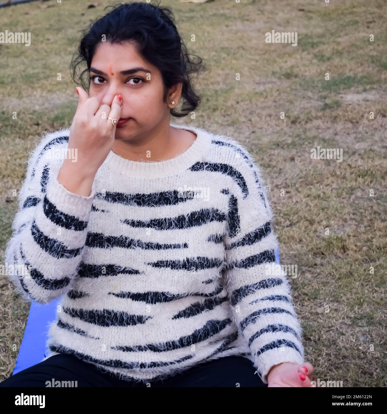 Young Indian woman practicing yoga outdoor in a park. Beautiful girl ...