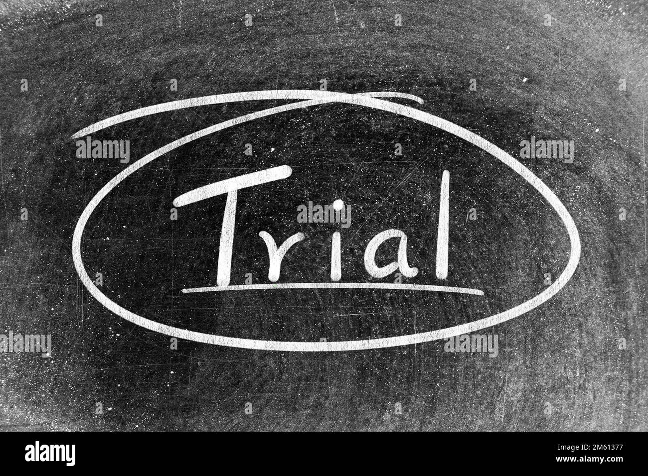White chalk hand writing in word trial and circle shape on blackboard ...