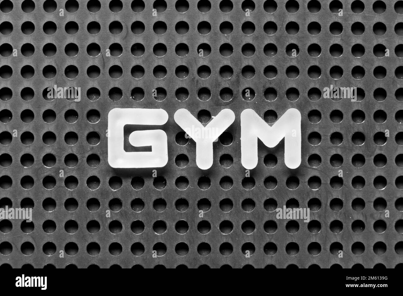 White alphabet letter in word gym on black pegboard background Stock ...