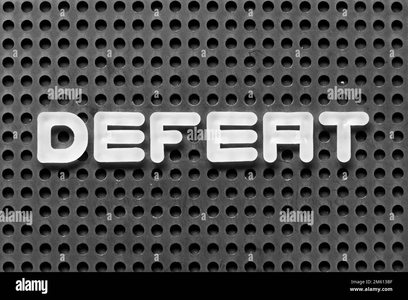 White alphabet letter in word defeat on black pegboard background Stock ...