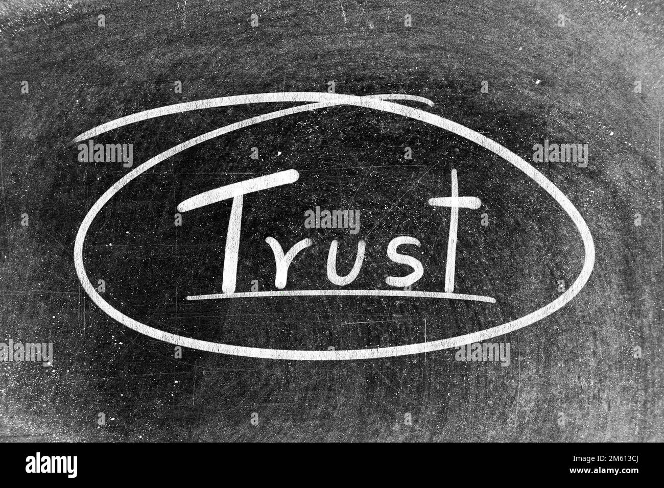 White chalk hand writing in word trust and circle shape on blackboard ...