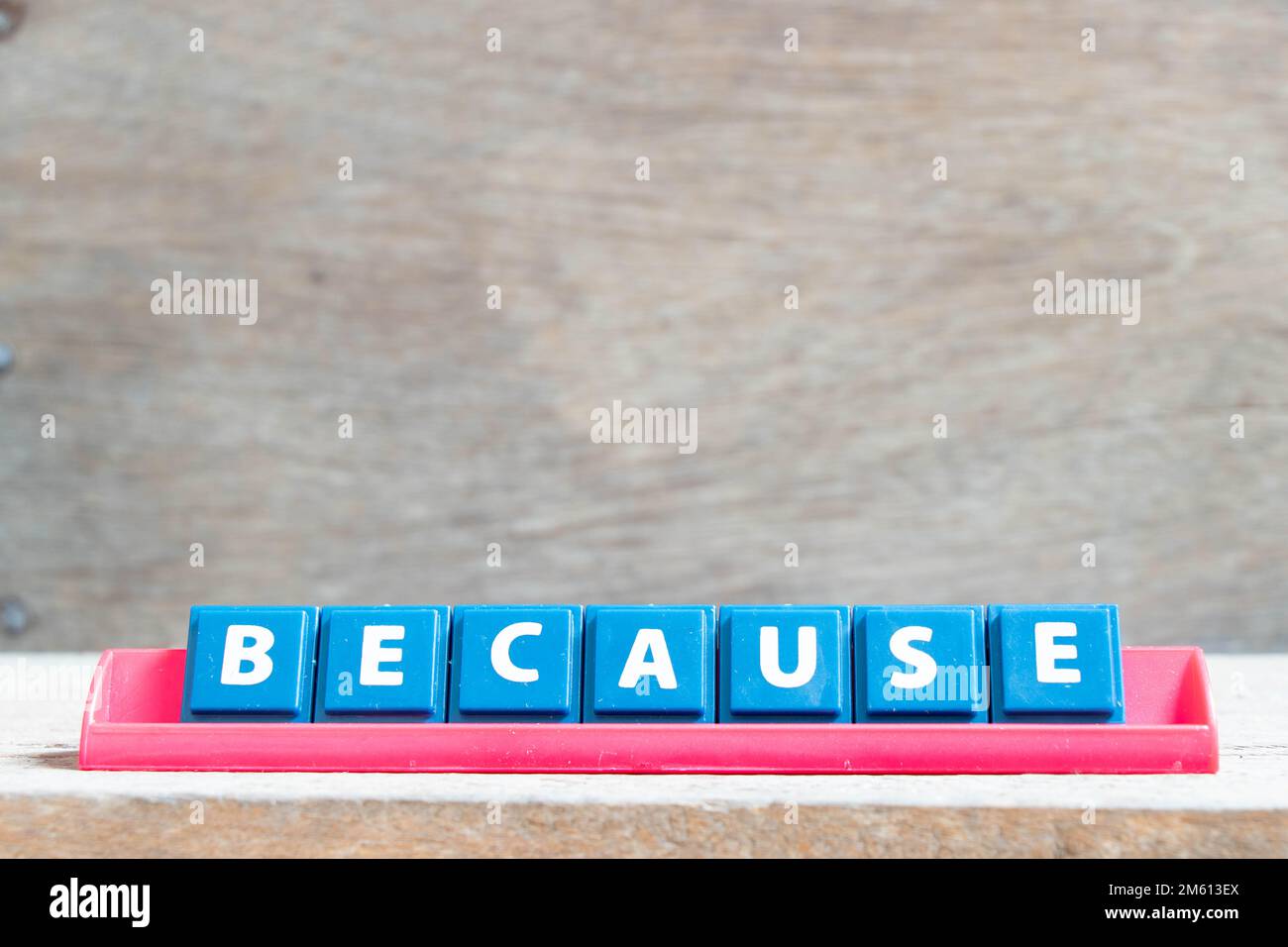 Tile alphabet letter with word because in red color rack on wood ...