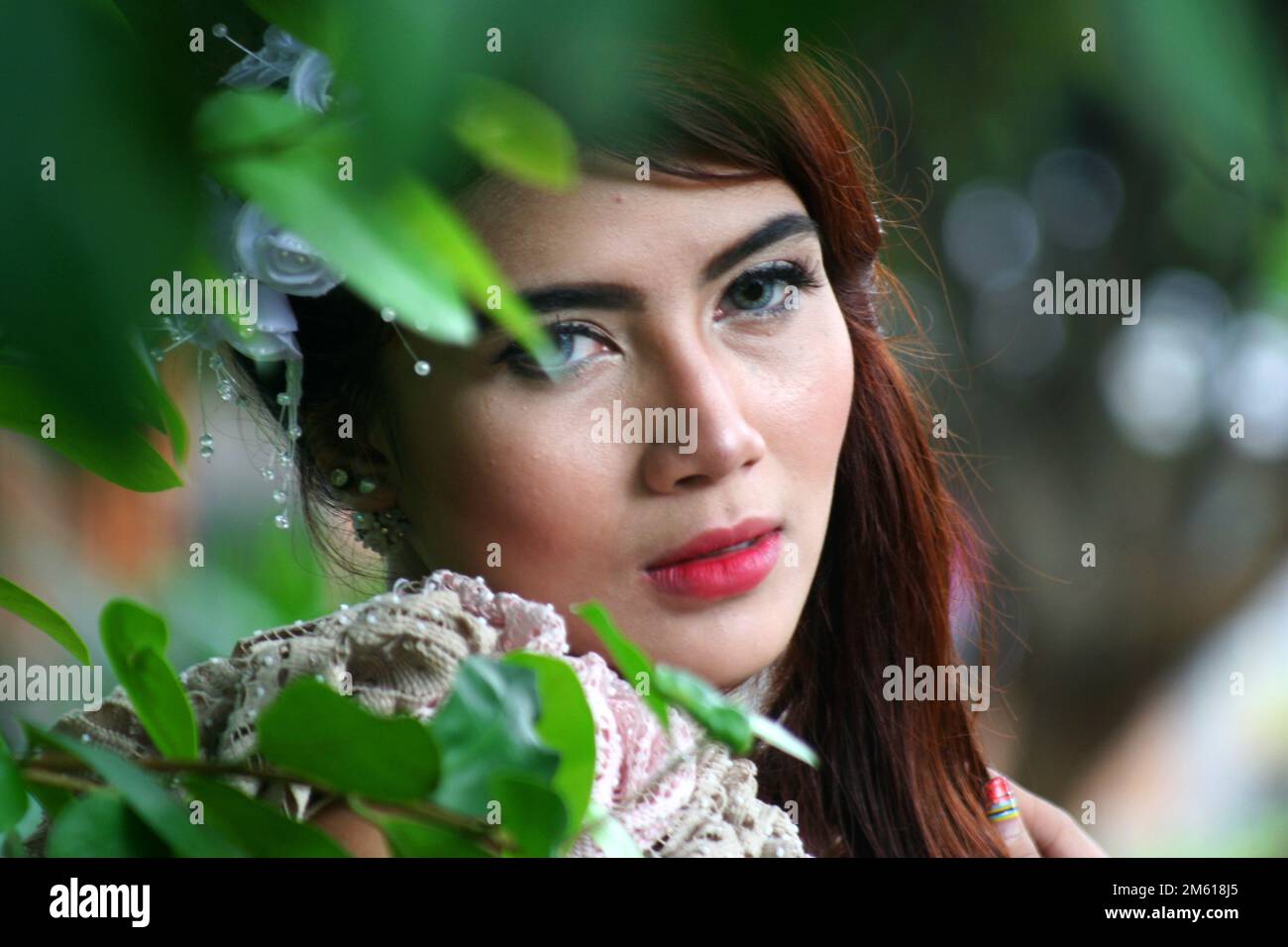 portrait of an Indonesian woman wearing a white flower decoration in ...