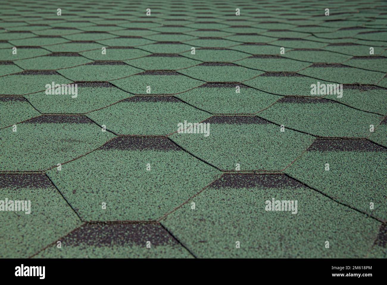 Roofing made of green soft bitumen tiles on a hipped roof of a house ...