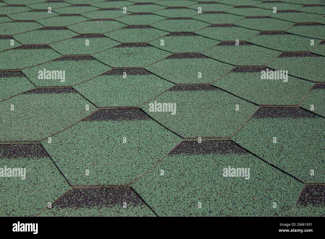 Roofing made of green soft bitumen tiles on a hipped roof of a house ...